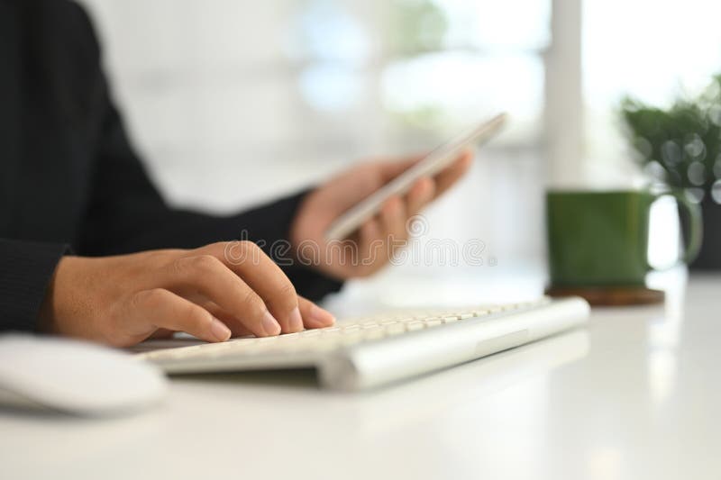 Close Up of Businesswoman Typing Computer Keyboard and Using Smartphone ...