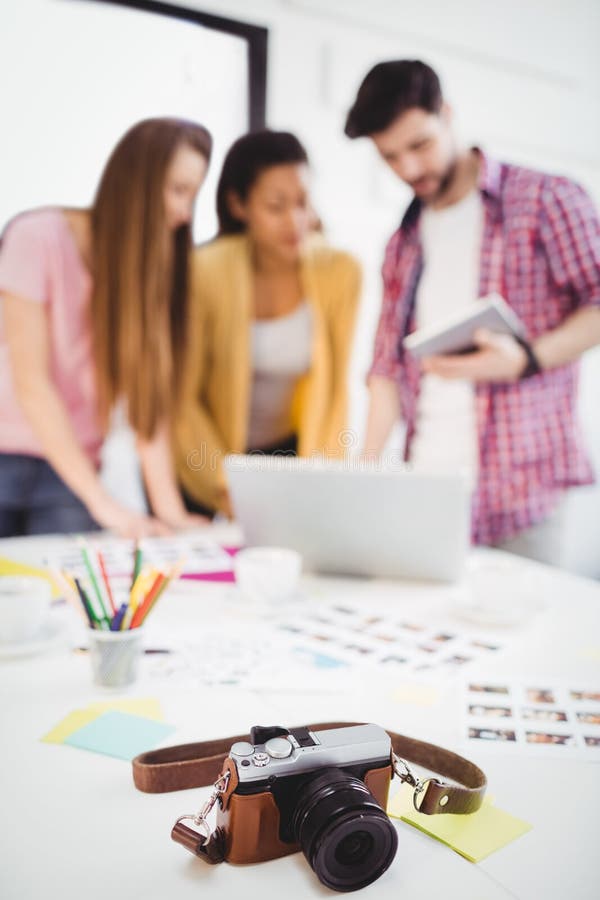 Close-up of Camera on Desk with Editors Working at Creative Office ...