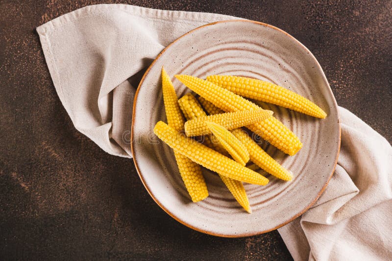 Close Up of Canned Mini Corn Cobs on a Plate on a Table Top View Stock ...