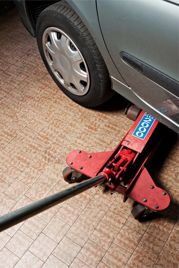 Close Up of Car Lifted with Car Jack at Auto Mechanic Workshop. Stock ...