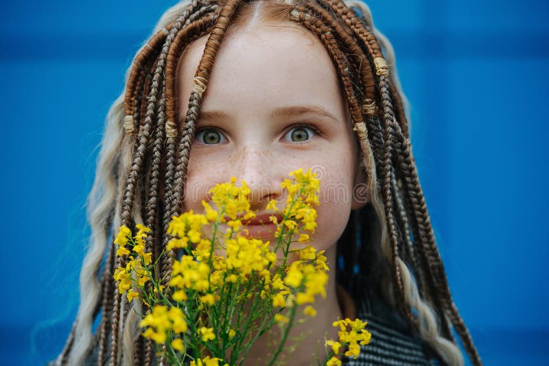 Close Up Of A Carefree Teenage Girl Looking At Camera Holding Yellow