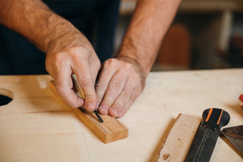 Close-up of Carpenter Hands Using a Chisel To Mark and Shape a Wooden ...