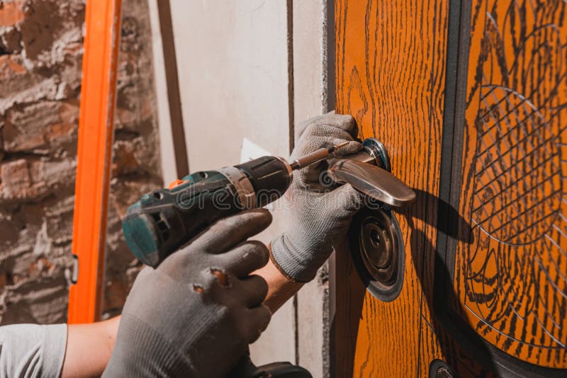 Close-up, the Carpenter Installs a Custom Lock in the Front Metal Door ...