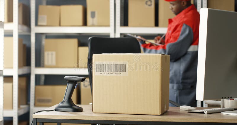 Close Up of Carton Box with Bar Code is on Table at Computer in Postal ...