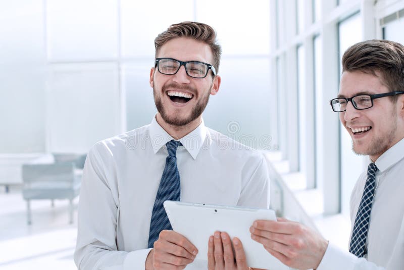 Close Up.cheerful Employees Looking at the Digital Tablet Screen Stock ...