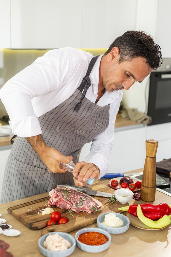 A Close-up of a Chef Adding Spices into a Piece of Meat Stock Photo ...
