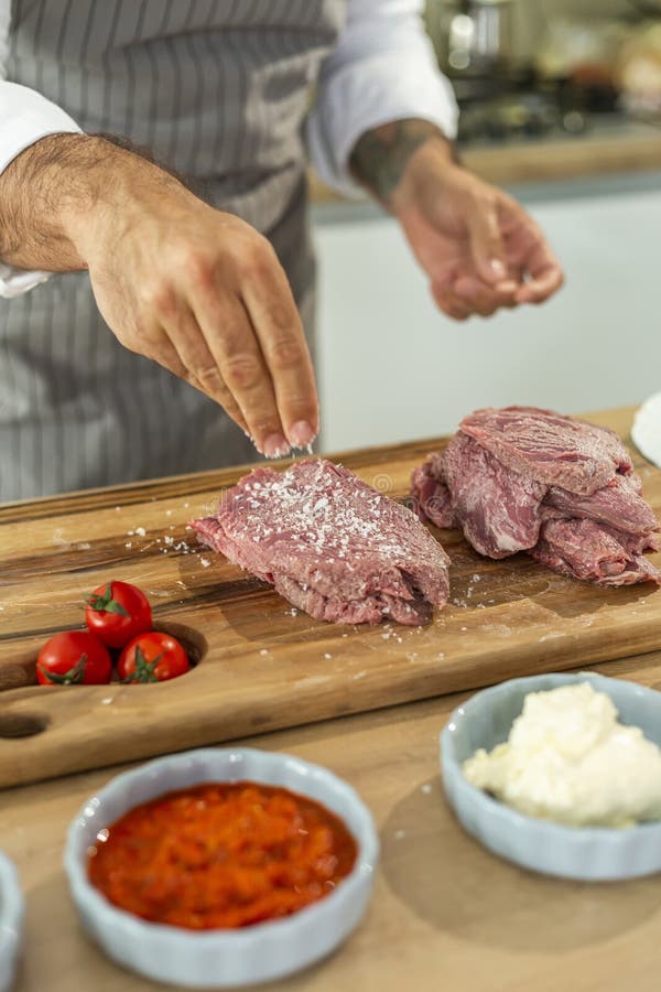 A Close-up of a Chef Adding Spices into a Piece of Meat Stock Photo ...