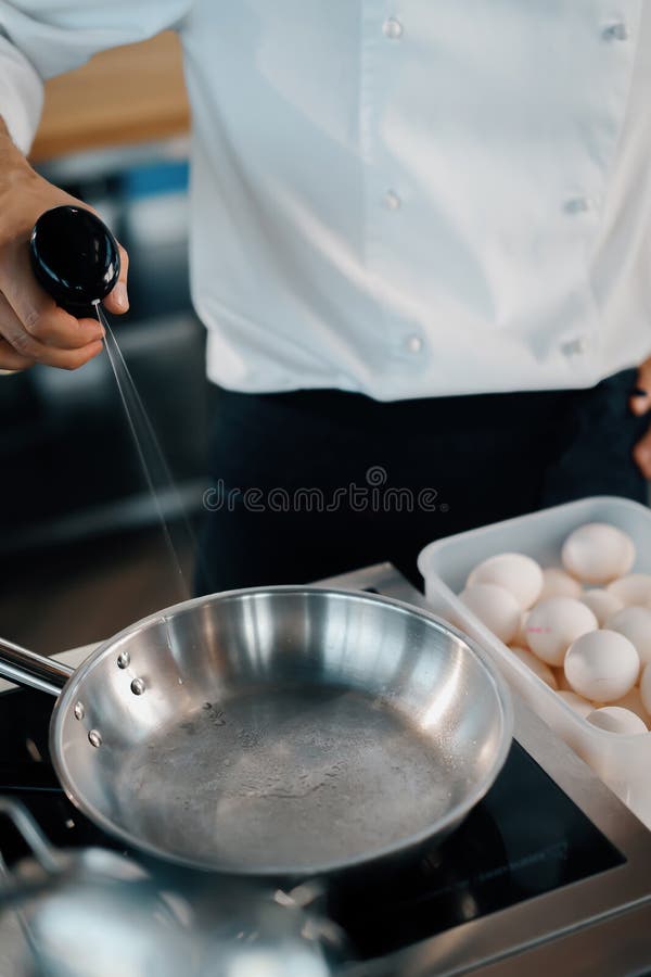Close-up of the Chef Splashing Oil into a Frying Pan. Frying Surface ...