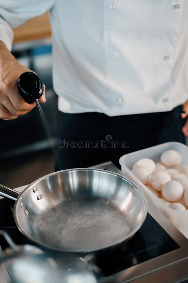 Close-up of the Chef Splashing Oil into a Frying Pan. Frying Surface ...
