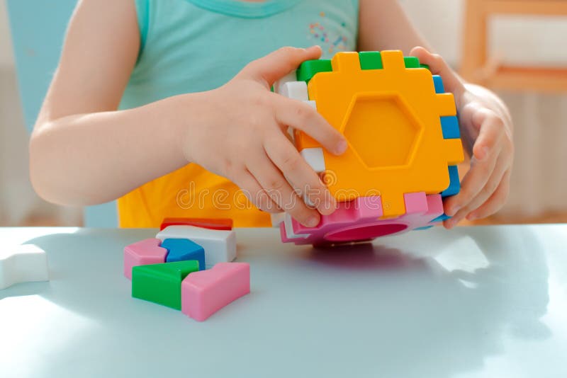 Close-up of the Child S Hands Collect Puzzle Sorter. Cube with Inserted ...