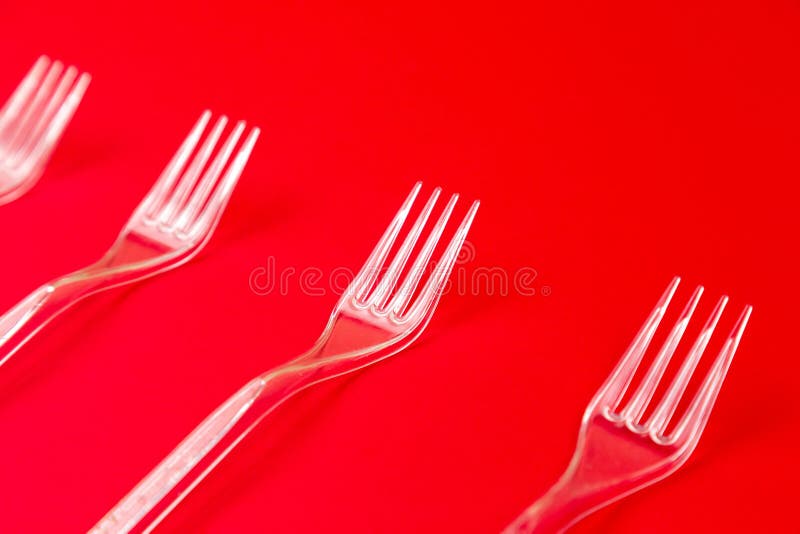Close-up of Clear Plastic Fork on a Red Background. Disposable ...