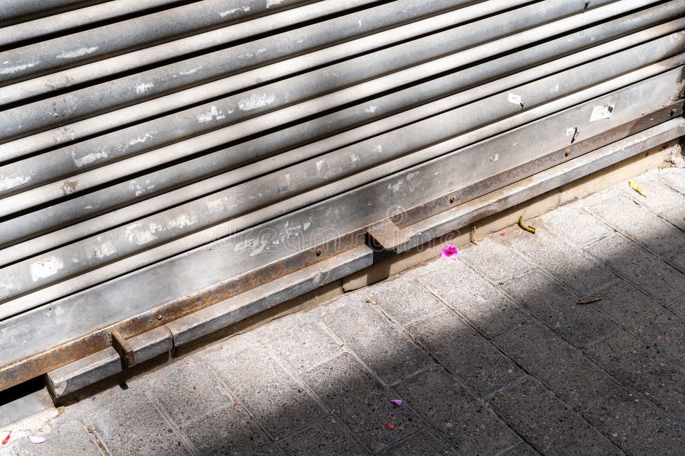 Close-up of a Closed Metal Shutter with Signs of Wear and Chipped Paint ...