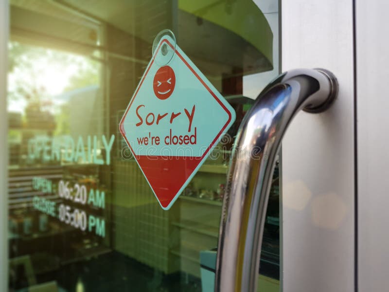 Close-up on a Closed Sign in the Window of a Shop with Text Sorry we ...