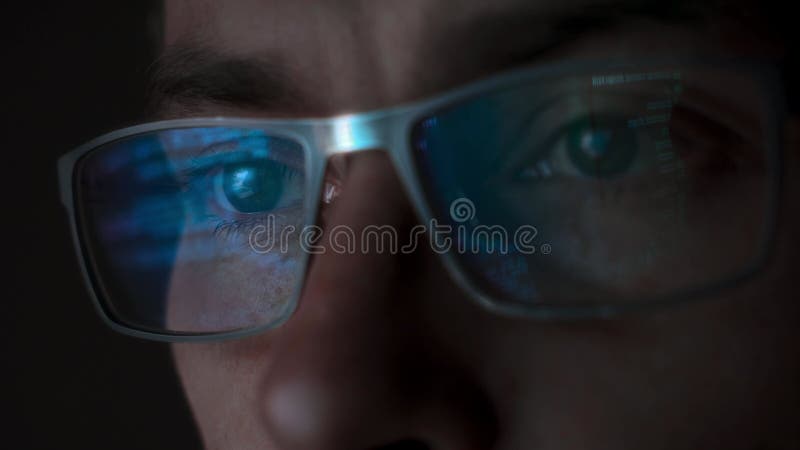 Close-up of a Coder Wearing Eyeglasses at Night, with Reflections of ...