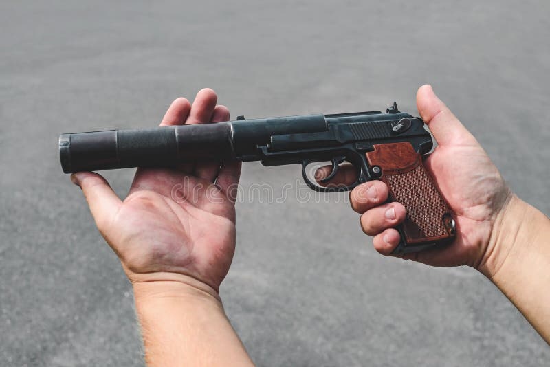 Close-up of a Combat Pistol with a Silencer in the Hands of a Man ...