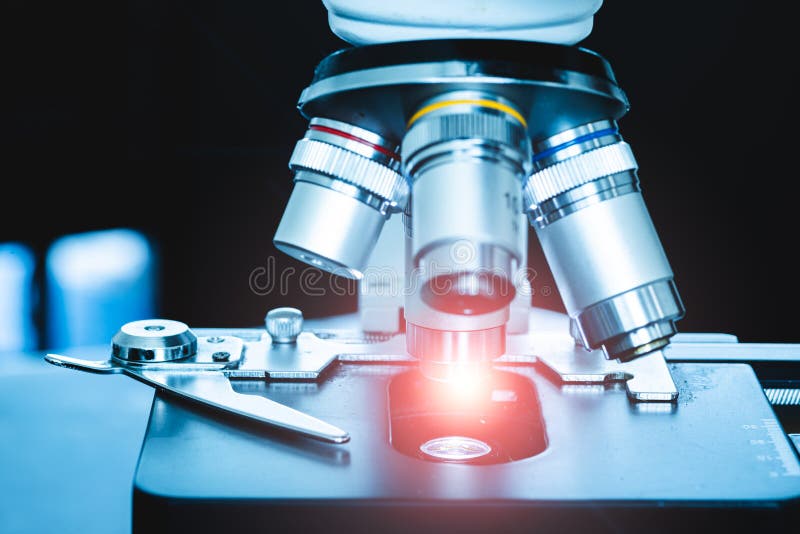 Close Up of Compound Microscope with Ray of Orange Light Shining in Lab ...