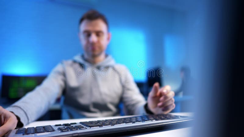 A Nervous Man is Typing on a Laptop Keyboard. Desperate Man at His Desk, Depressed. Silhouette ...