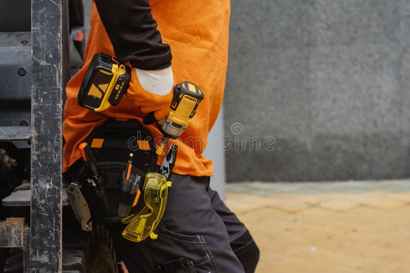 Close-up of a Construction Worker with a Tool Belt, Wearing Protective ...