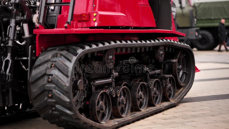 Continuous Track of Modern Red Tractor Staying on Paved Ground Stock ...