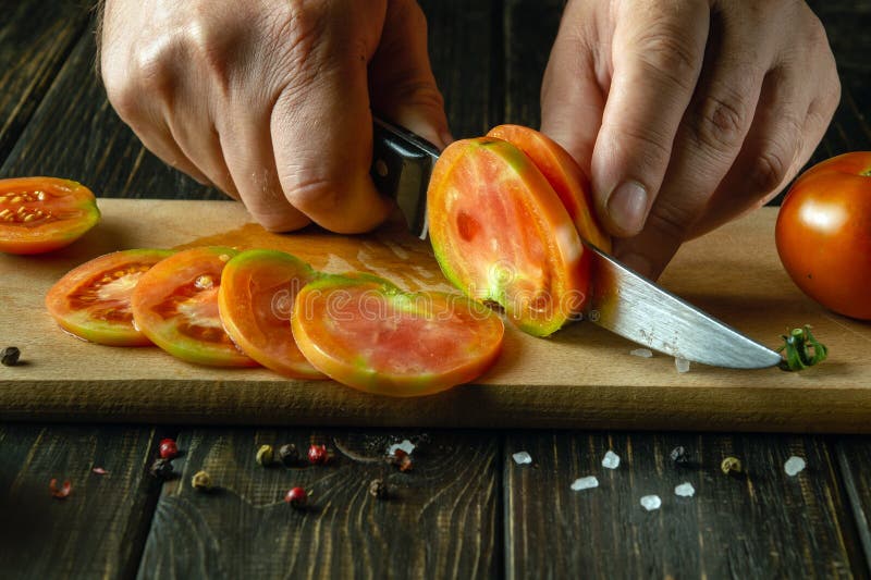 Close-up of a Cook Hands with a Knife Cutting a Tomato into Small ...