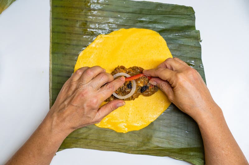 Preparing a Venezuelan Hallaca with Ingredients Being Added by Hand ...