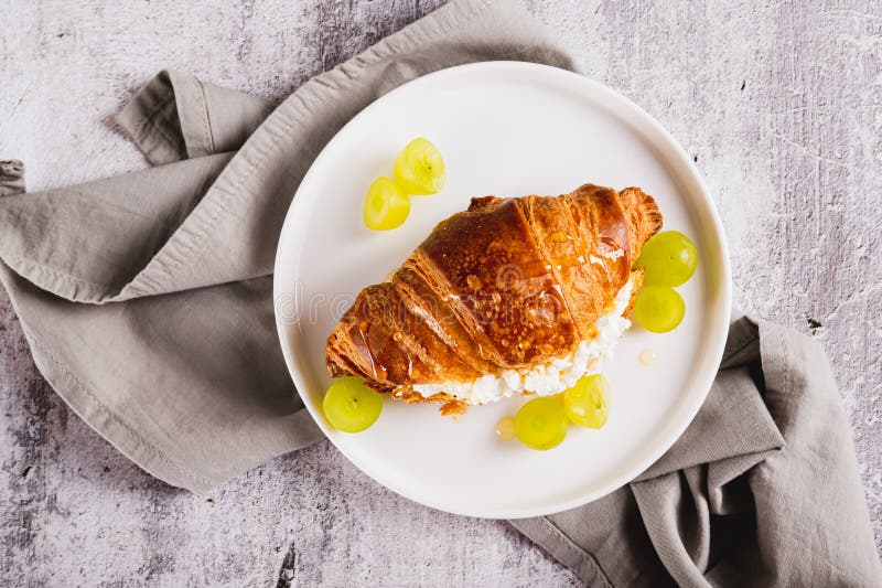 Close Up of Croissant with Cottage Cheese and Grapes on a Plate on the ...