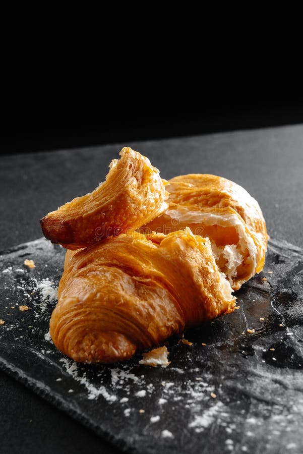 Close-up of Croissants on a Dark Background. One Croissant Broken into ...