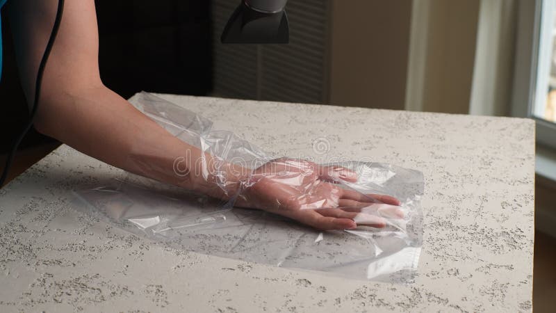 Close-up Cropped Shot of Unrecognizable Man Heats Up Shrink Wrap with ... Close-up Cropped Shot of Unrecognizable Man Heats Up Shrink Wrap with ...