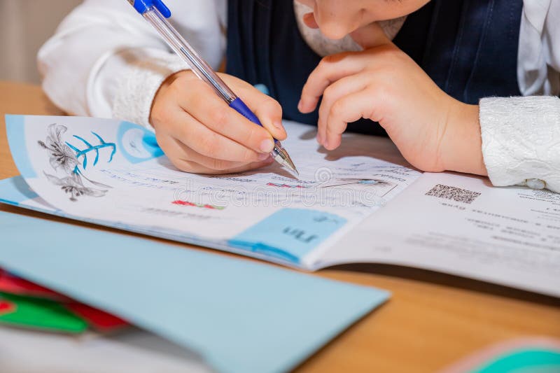 Close-up Cropped Shot of Unrecognizable Pupil Boy Studying at Home Writing in Exercise Book ...