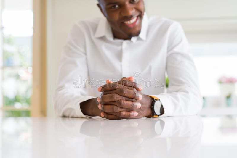 Close Up of Crossed Hands of African Man Over Table Smiling Stock Photo ...