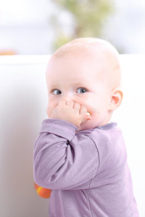 Close Up.cute Baby Eating a Cookie while Sitting on the Couch Stock ...
