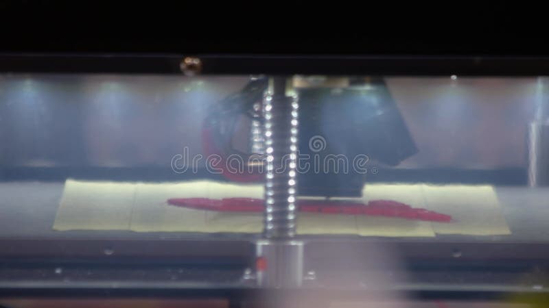 3D Printer Creating a Red Gear Shape on a Flat Surface in a Workshop ...