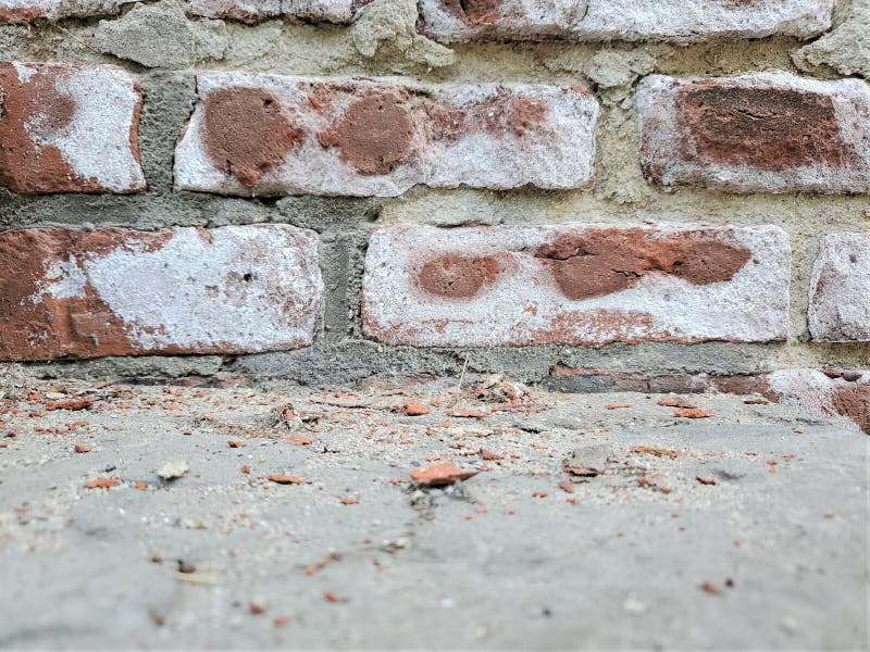 Close Up of Damage To Crumbling Red Brick and Mortar Wall Over Stone ...