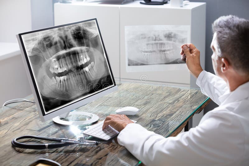 Dentist Typing on Computer with Dental X-ray on Screen Stock Photo ...