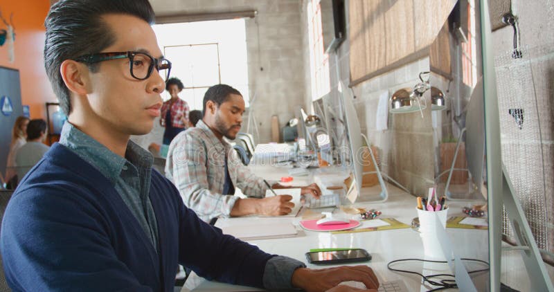 Close Up of Designers at Desks Working on Computers in Modern Office ...