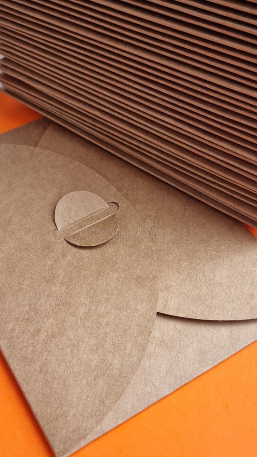 Stack of Brown Kraft Paper Envelopes with Round Clasp on Orange ...