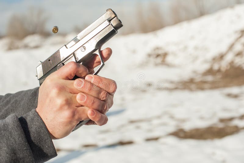 Close-up Detail View of Shooter Hands Holding Gun and Shooting Stock ...