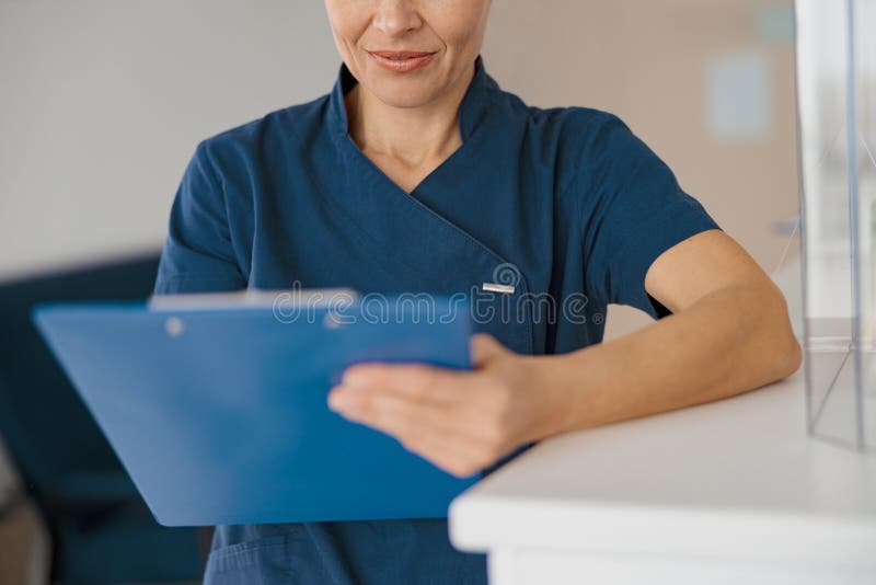Close Up Doctor Making Notes on Clipboard Standing Near Reception in ... Close Up Doctor Making Notes on Clipboard Standing Near Reception in ...