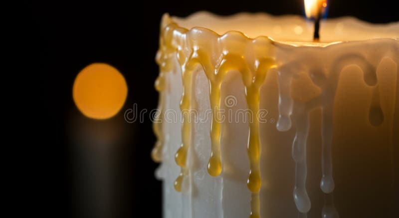 Close-up of Dripping White Candle with Yellow Wax in Dark Background ...