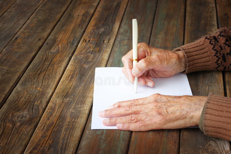 Close Up of Elderly Male Hands on Wooden Table . Writing on Blank Paper ...