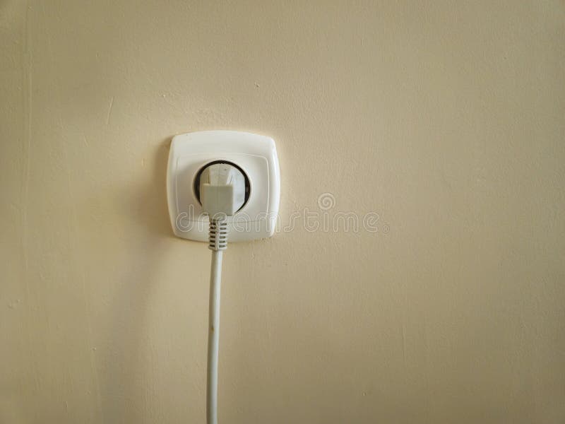 A Close-up of an Electrical Outlet with a Plug Inserted, Set Against a ...