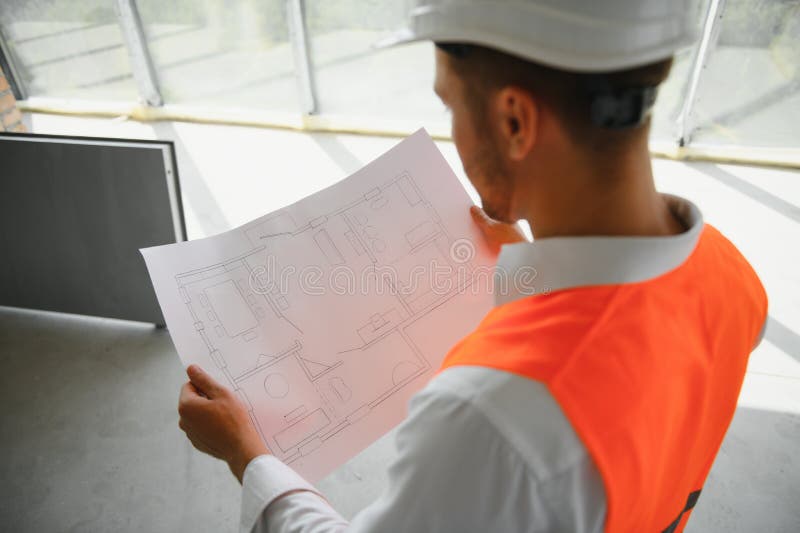Close Up Engineers Working on a Building Site Holding a Blueprints ...