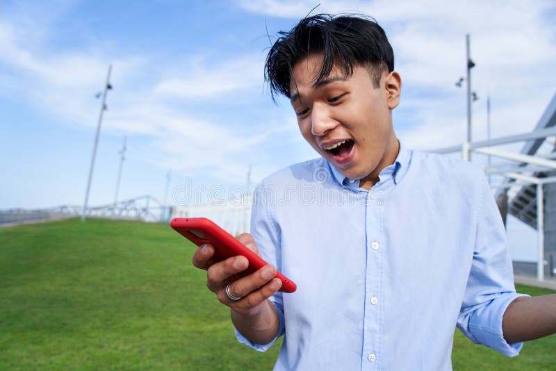 Close Up of an Excited Asian Boy Using Smart Phone Gesturing Surprise ...