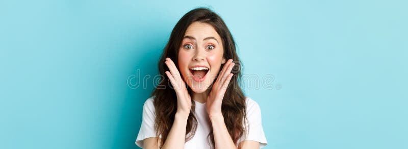 Close Up Of Excited Young Woman Holding Hands Near Face Gasping And
