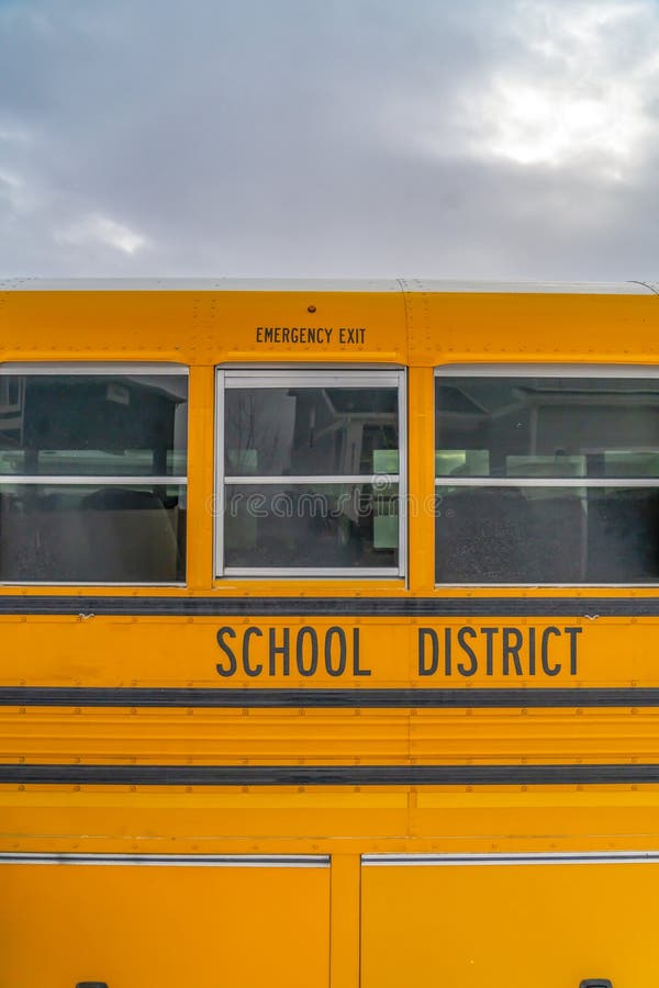CLose Up of the Exterior of a Yellow School Bus Against Cloudy Sky ...
