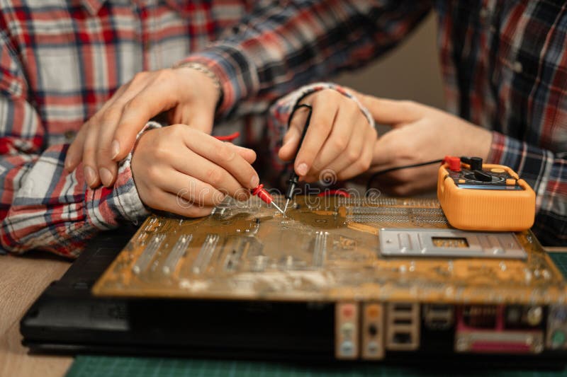 Close-up of Father and Son Hands Testing Laptop Motherboard Using ...