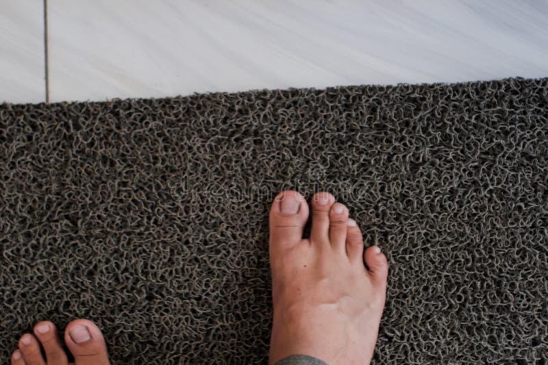 Close Up Feat on a Mat at the Home As a Man is Seen Entering through ...