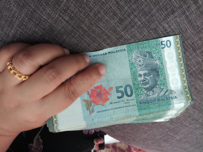 Close Up of Female Hand Holding Malay Cash on Sofa. Ringgit Malaysia on ...