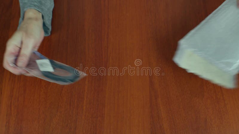 Close-up of Female Hands Opening a Small Parcel in a Plastic Package ...