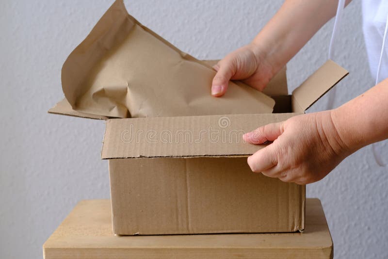 Close-up of Female Hands Take Out Package from Open Cardboard Box of ...
